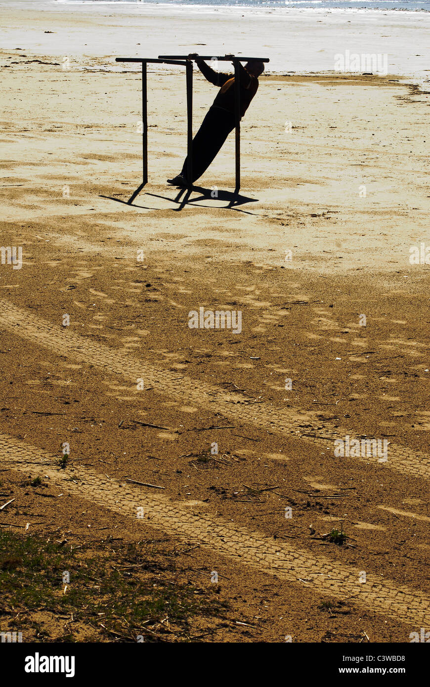 Man doing parallel bars on the beach Stock Photo - Alamy