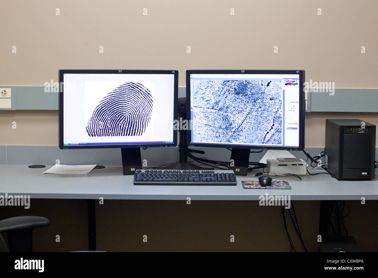 Computer monitors show fingerprint being studied by analyst at the ...