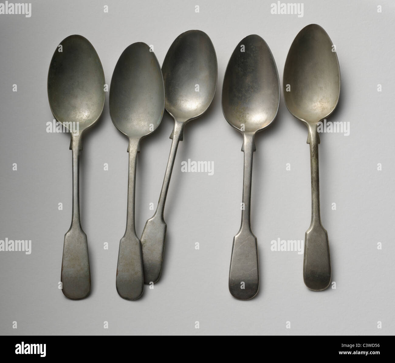 old used spoons on a white background Stock Photo - Alamy