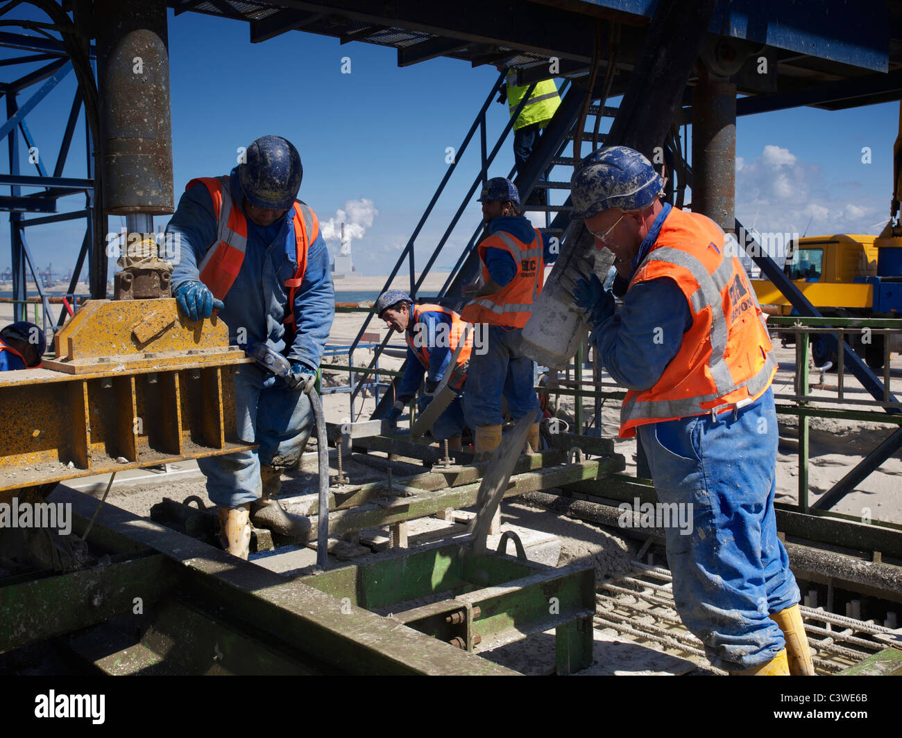 Workers pouring concrete making a new quay of the deep sea port ...