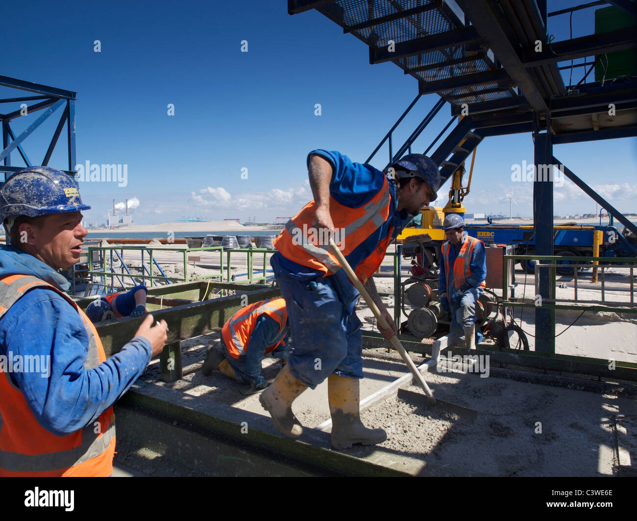 Workers pouring concrete making a new quay of the deep sea port ...