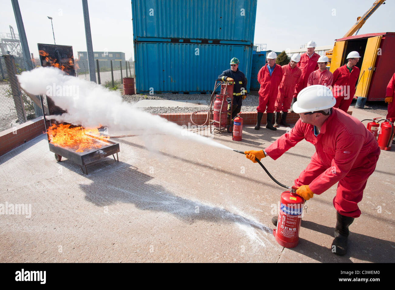 Workers in the offshore industry practice fire fighting with a powder ...