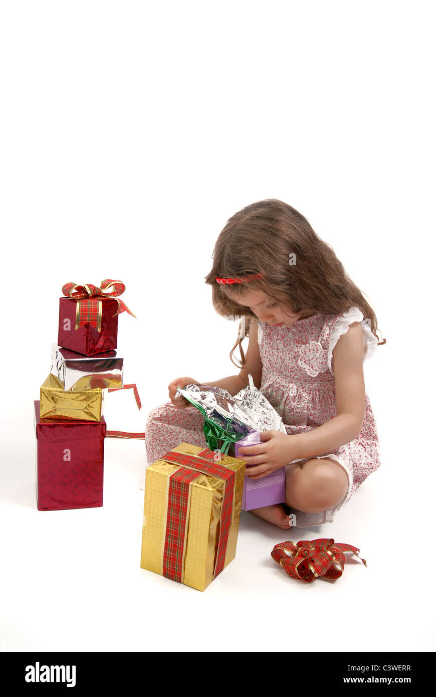 Little girl opening her Christmas presents. White background Stock ...