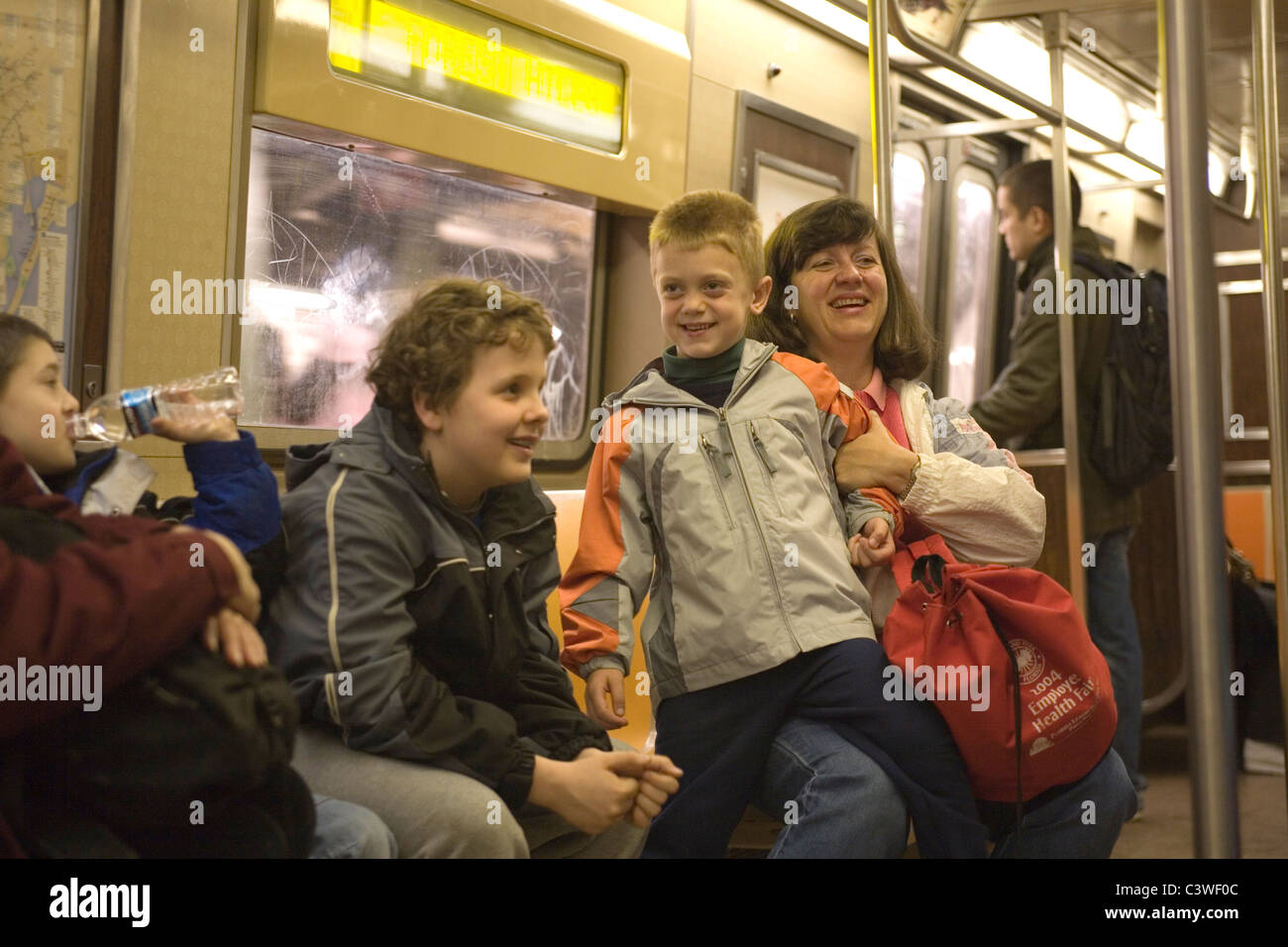 Mother and children having a good time on a New York City subway train ...