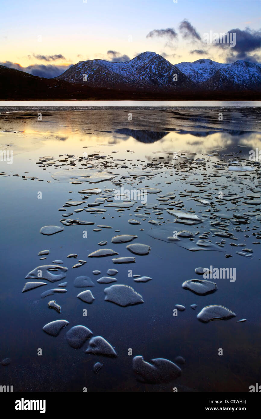 Snow-clad mountains and icy waters of Lochan na h-Achlaise in Rannoch ...