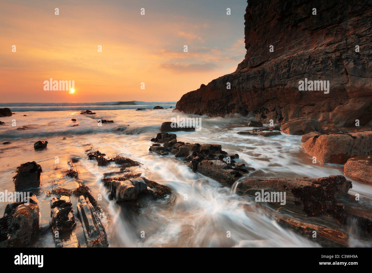 A calm summer's evening along the dramatic shores of Sandy Mouth Bay in ...