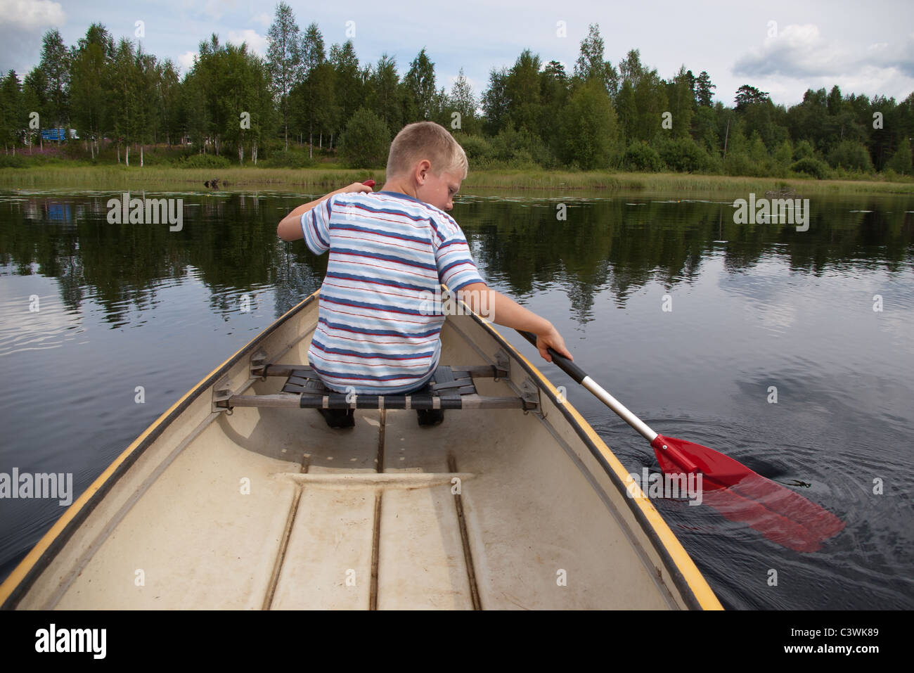 Boy rowing in a canoe on a lake in Sweden Stock Photo - Alamy