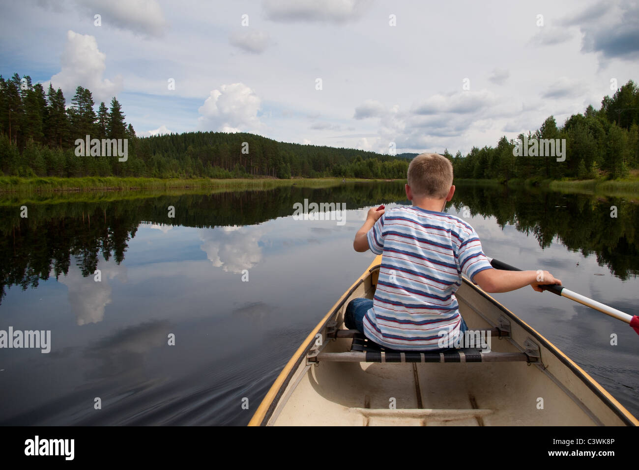 Boy rowing in a canoe on a lake in Sweden Stock Photo - Alamy