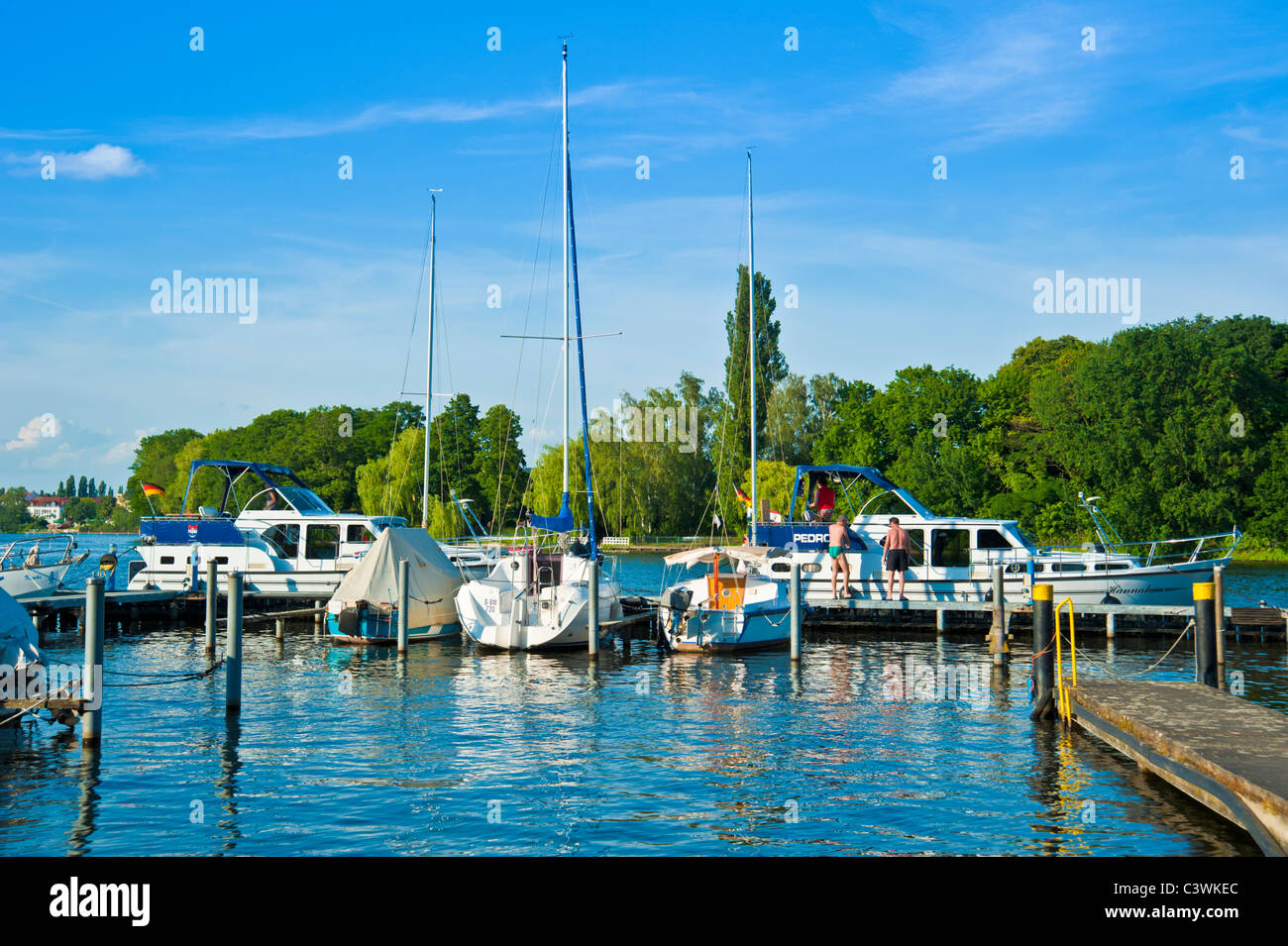 Sailing yachts and power boats moored on landing stage at marina, River ...