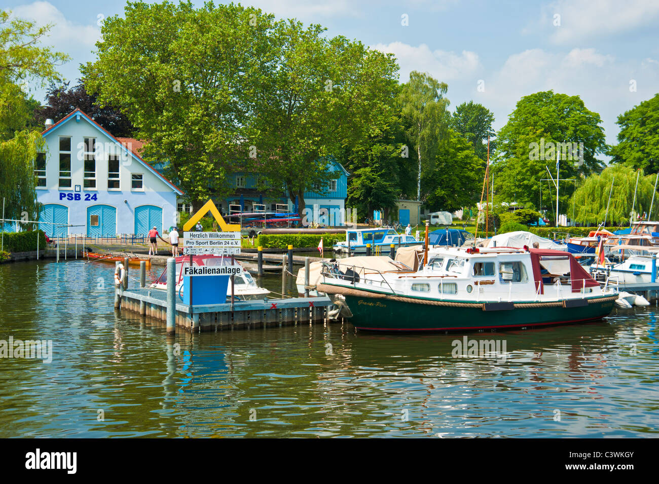 Sailing yachts and power boats moored on landing stage at marina, River ...