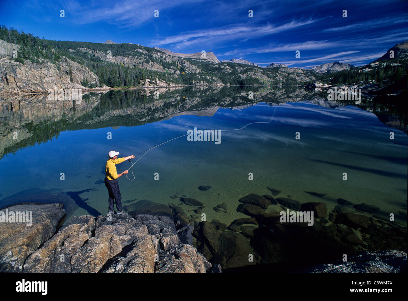 Man casting line into lake Stock Photo - Alamy