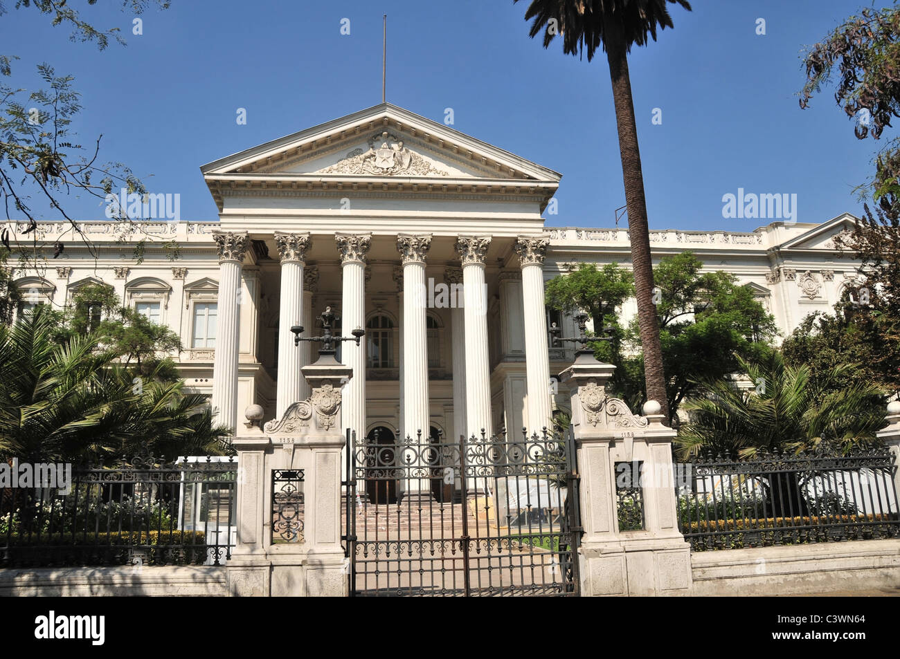 Blue sky view of the neo-classical entrance facade, gate and garden ...