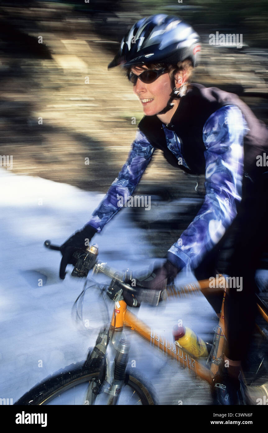 Woman mountain biking in snow Stock Photo - Alamy