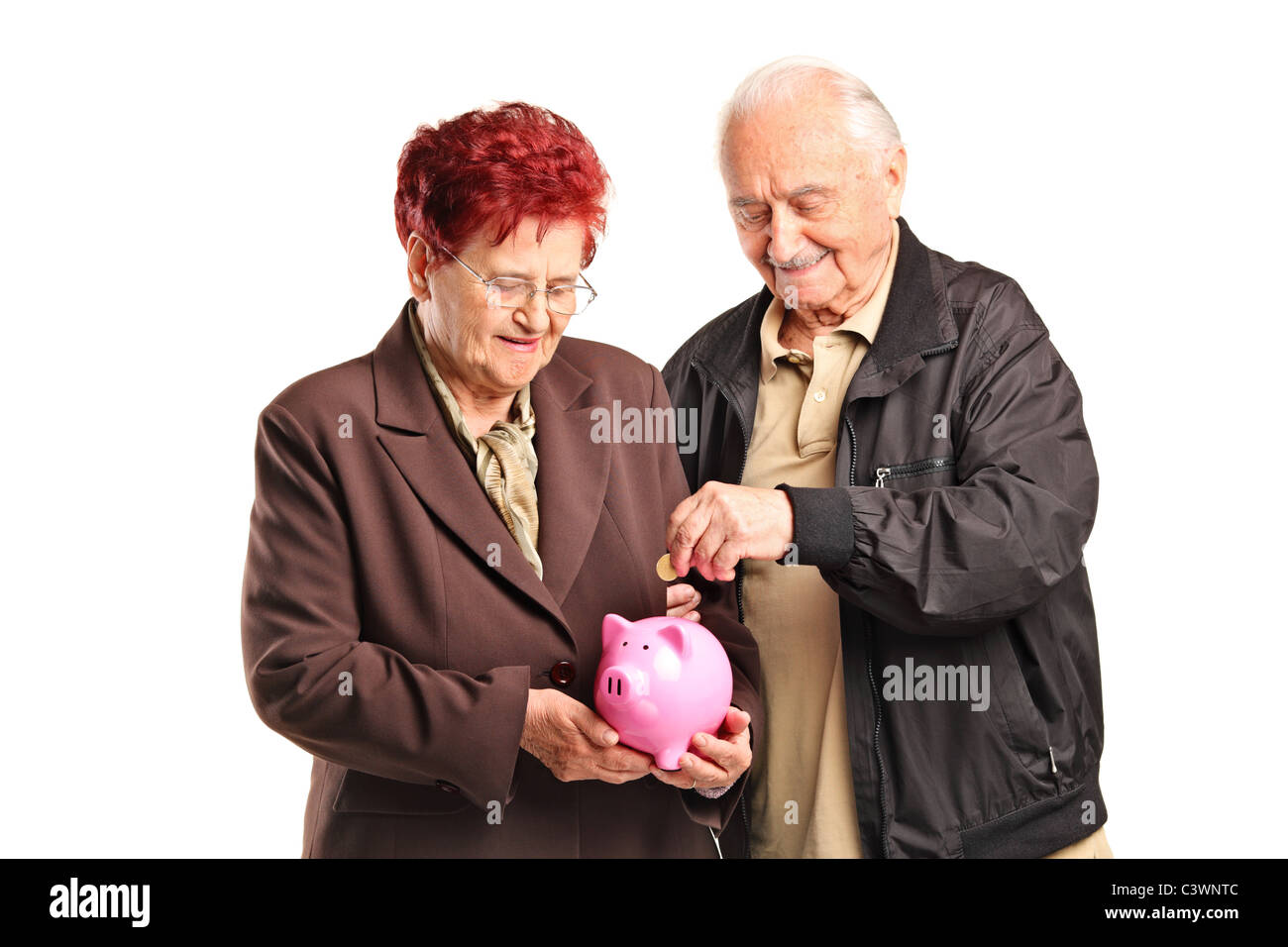 A happy old couple putting a coin into a piggy bank Stock Photo - Alamy