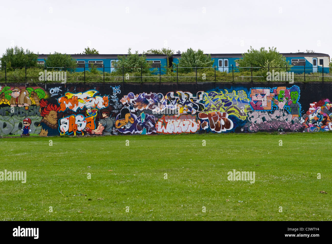 Urban graffiti artwork on brick wall of railway embankment in Cardiff ...