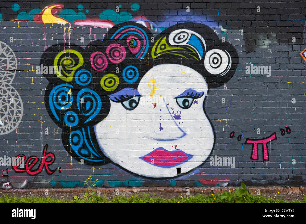 Urban graffiti artwork on brick wall of railway embankment in Cardiff ...