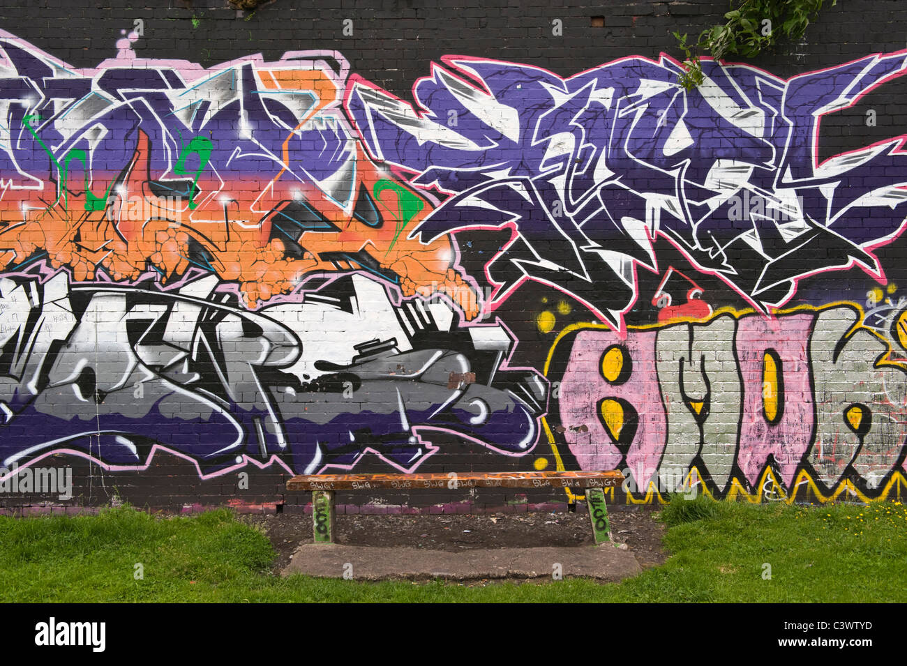 Urban graffiti artwork on brick wall of railway embankment in Cardiff ...