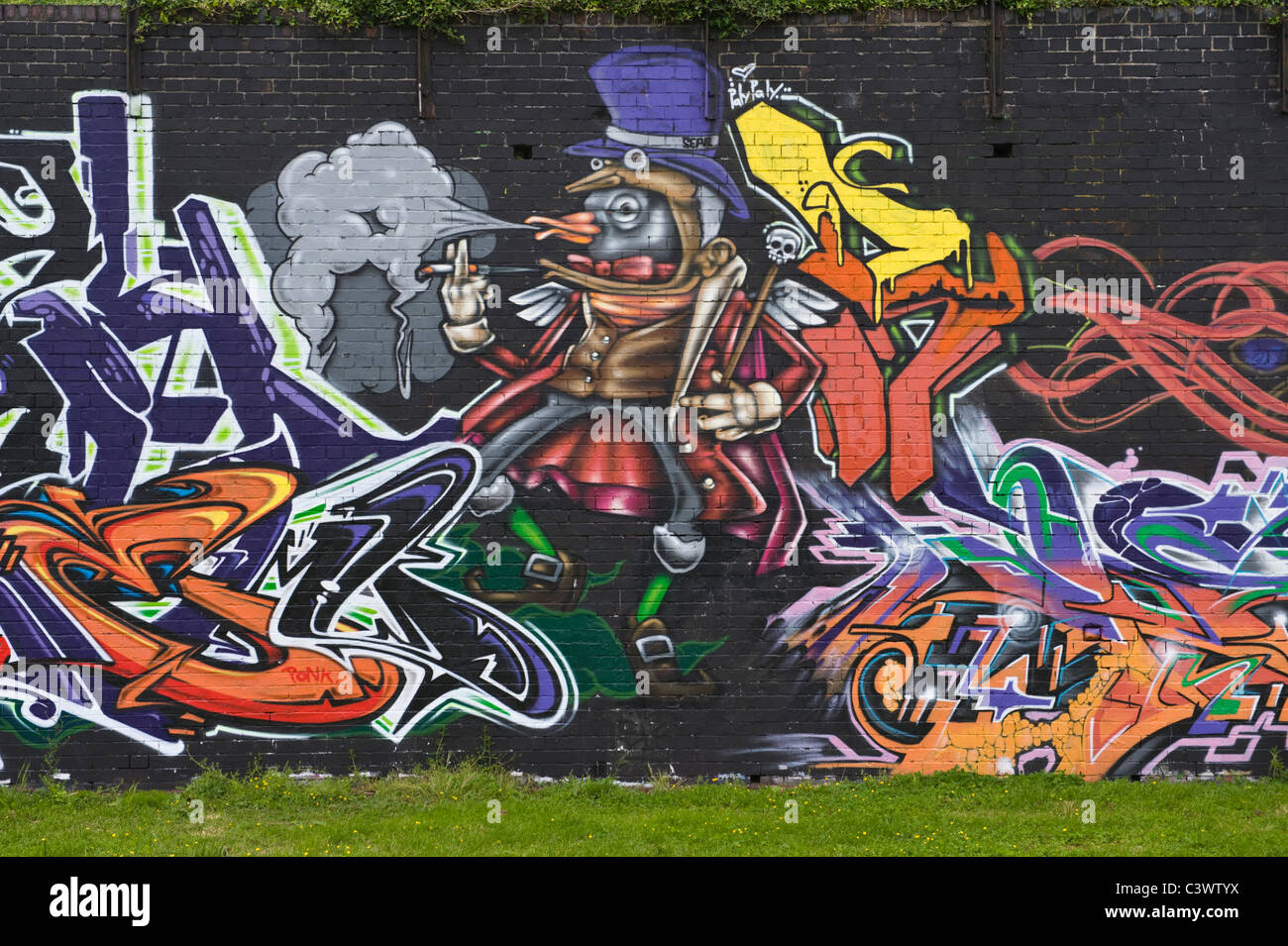 Urban graffiti artwork on brick wall of railway embankment in Cardiff ...