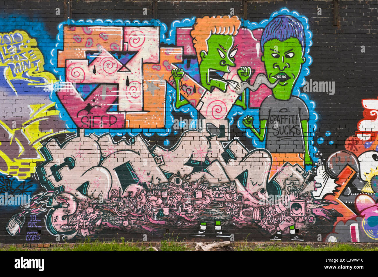 Urban graffiti artwork of on brick wall of railway embankment in ...
