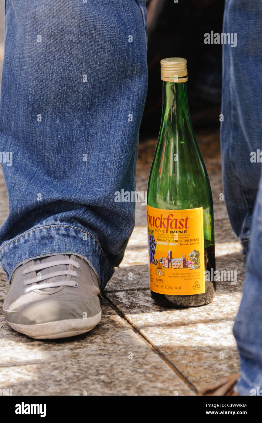 Bottle of Buckfast at the feet of a man Stock Photo - Alamy
