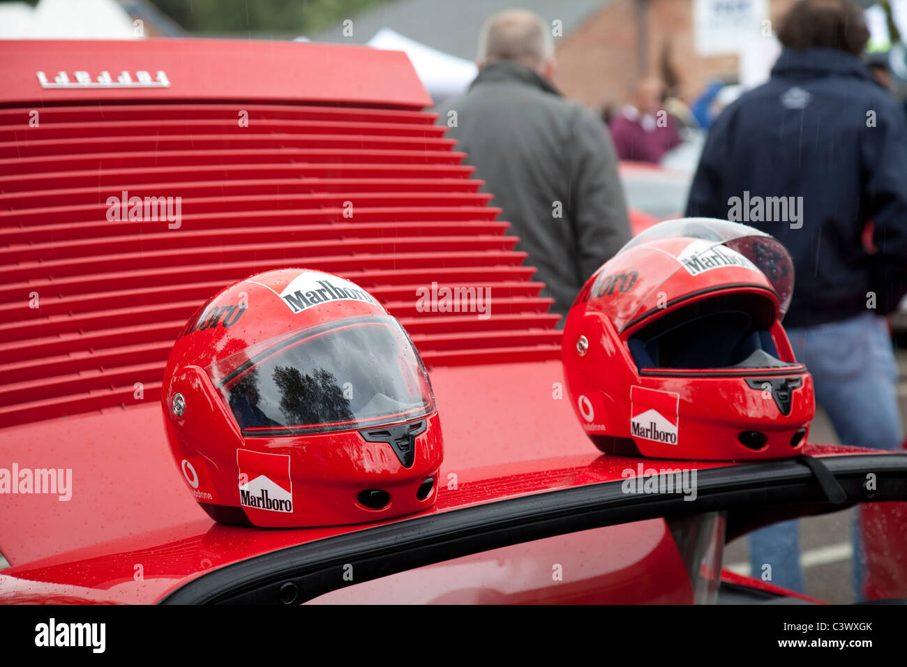A pair of racing safety helmets on top of a Ferrari supercar England UK ...