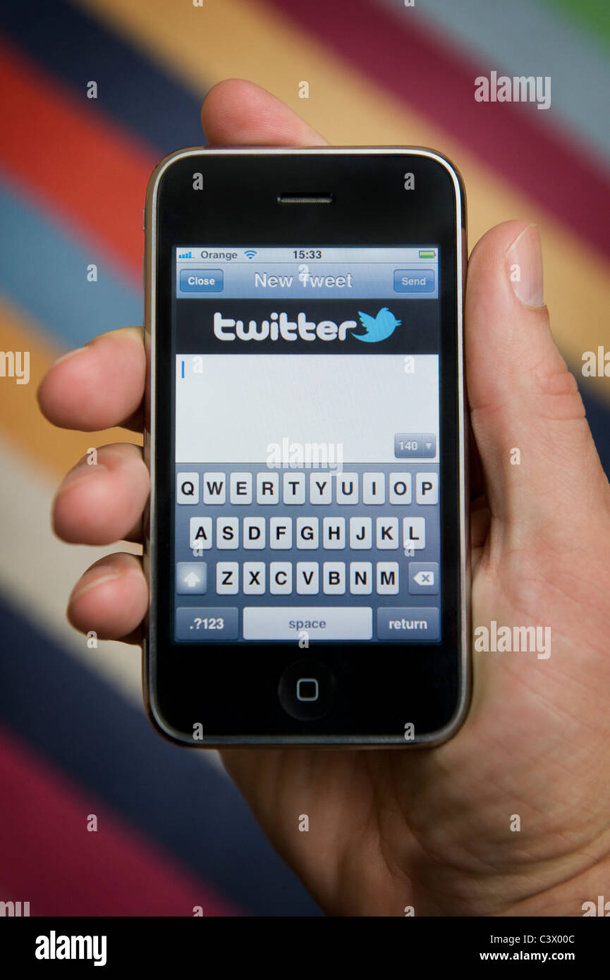 Close up of male hand holding an iPhone about to compose a Twitter ...