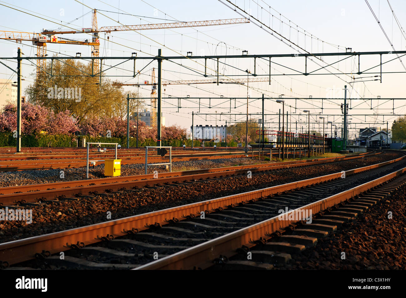 A Dutch trainstation seen from the railroad on a sunny late afternoon ...