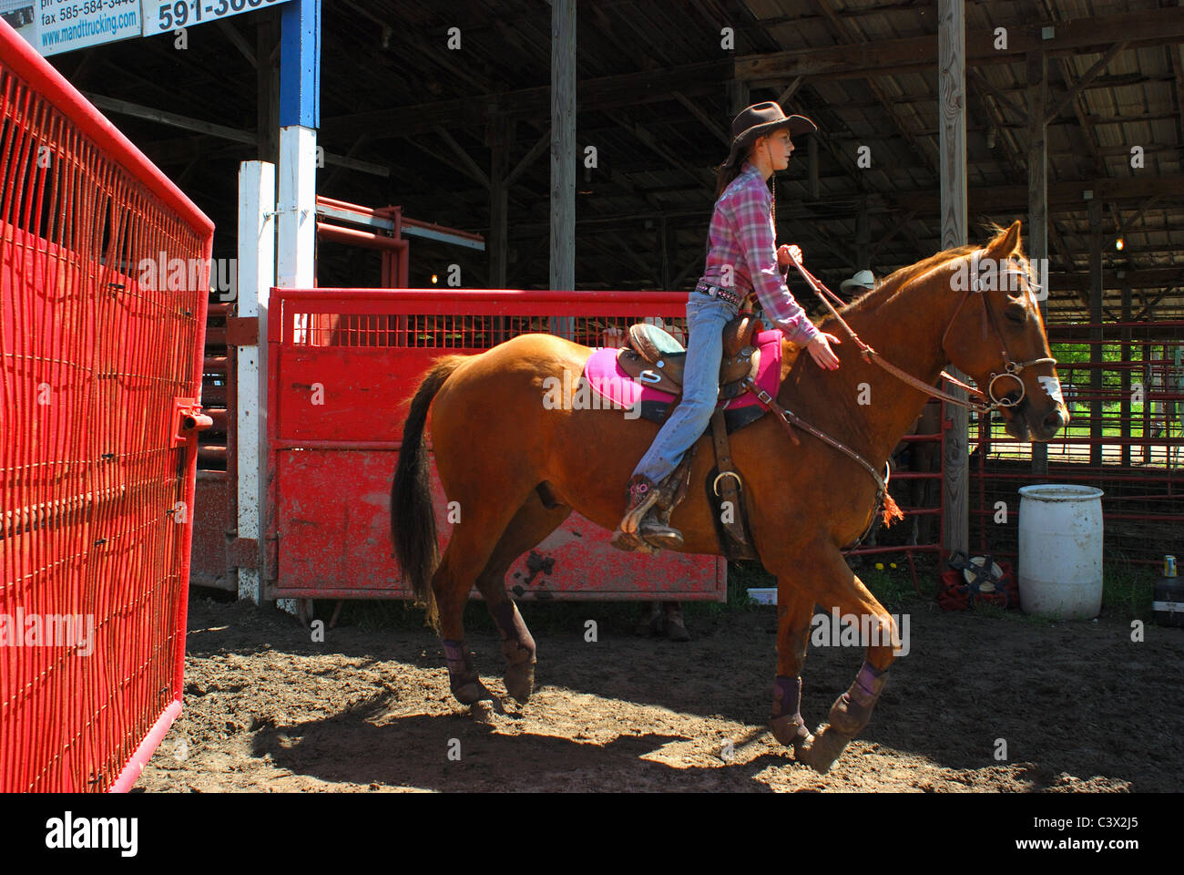 High school girl rides her horse through red gates Stock Photo - Alamy