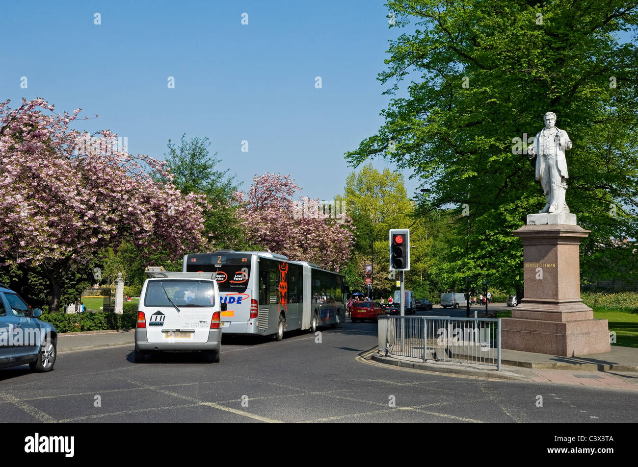 Traffic queuing at Station Road in spring and statue of George Leeman ...