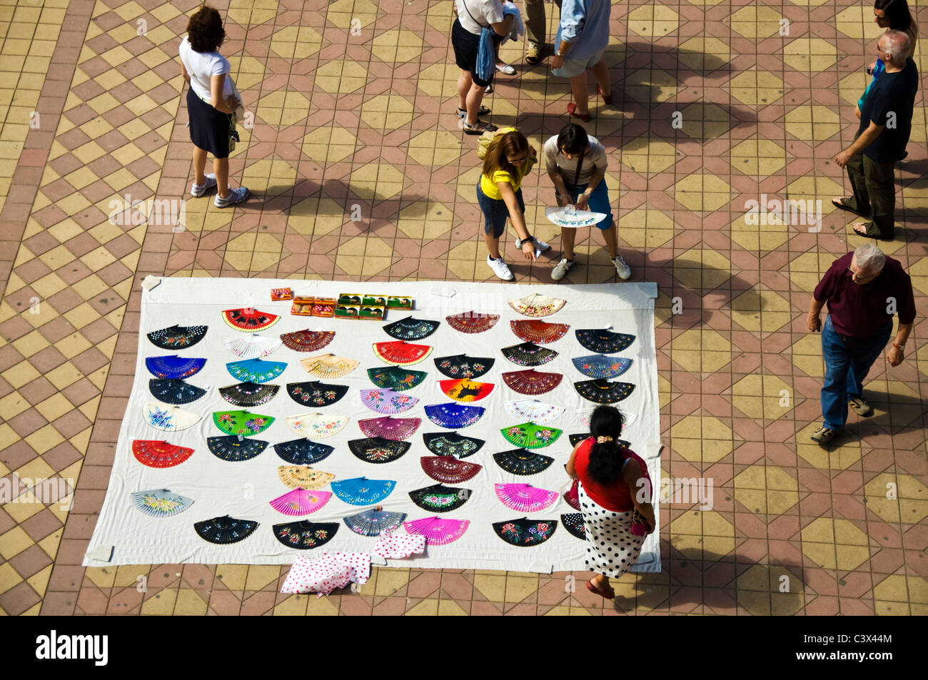 Tourists looking at a display of fans at Plaza de Espana Sevilla ...