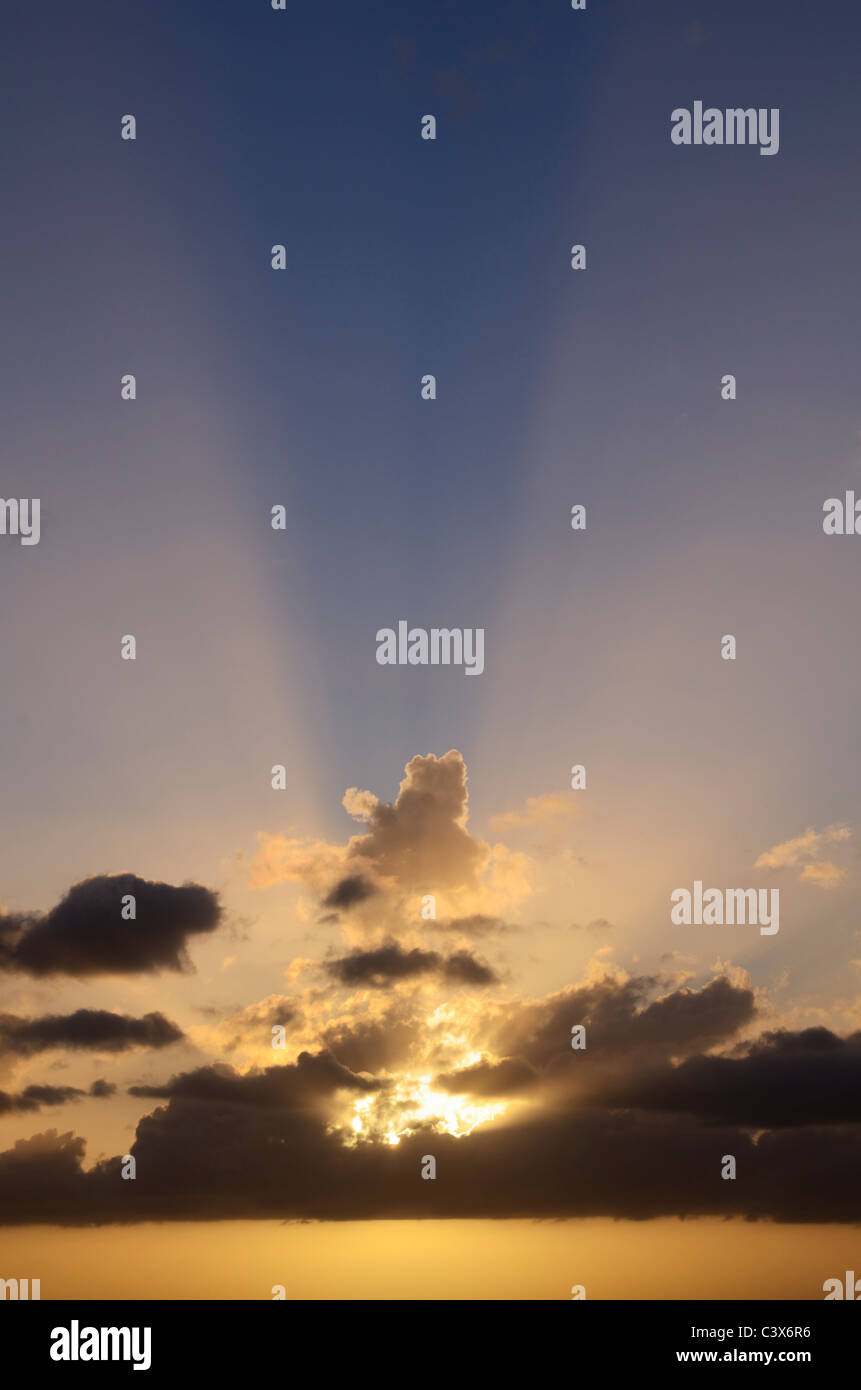 Sunbeams bursting through cloud at sunset Stock Photo - Alamy