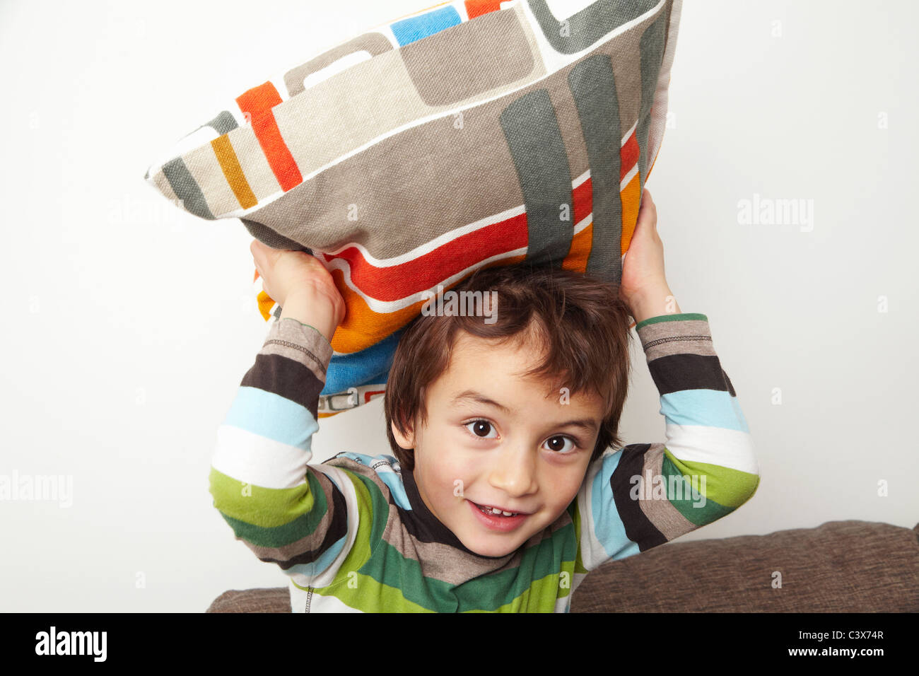 Boy throwing cushion Stock Photo - Alamy