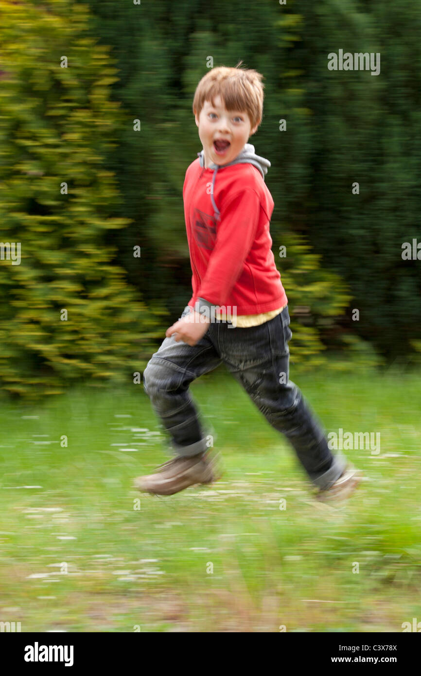 little boy running across a meadow Stock Photo - Alamy