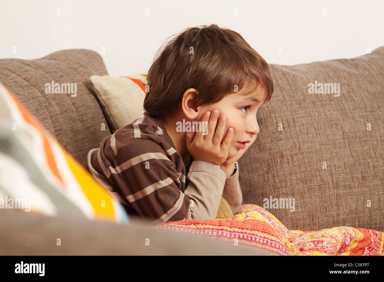 Boy on sofa staring at television Stock Photo - Alamy