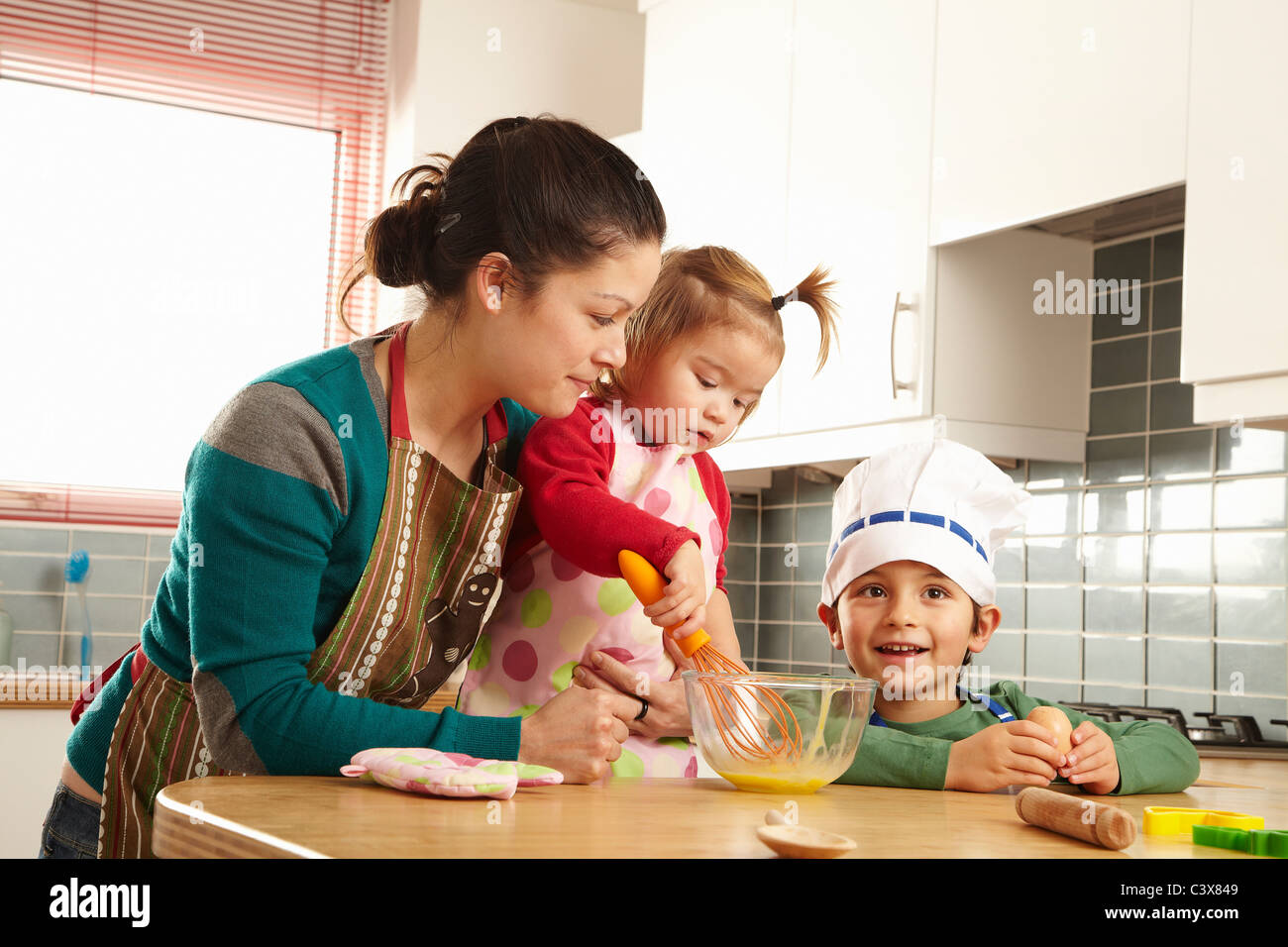 Mother cooking with children in kitchen Stock Photo - Alamy