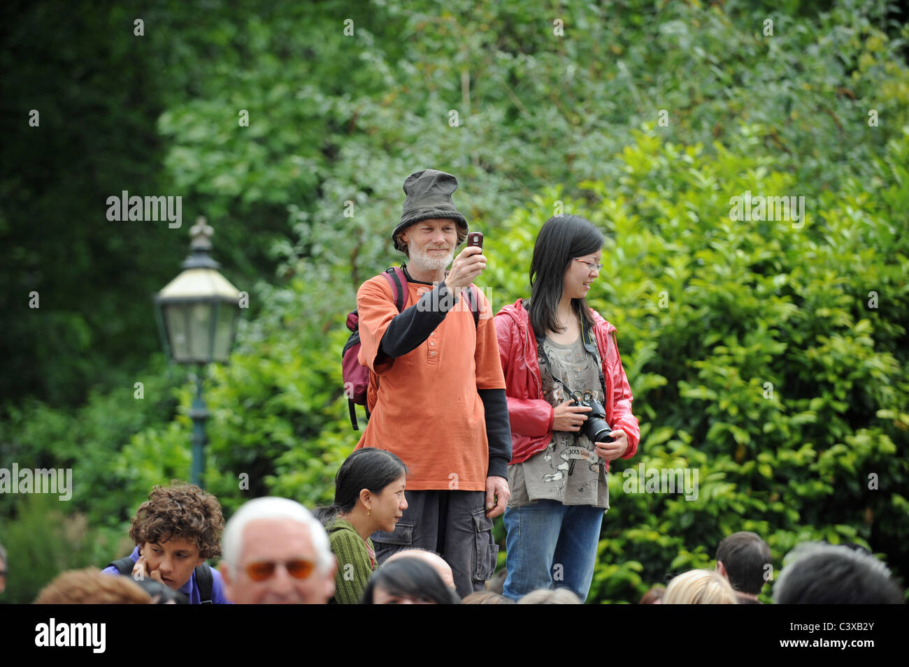 Getting above the crowd spectators watch and photograph outdoor street ...