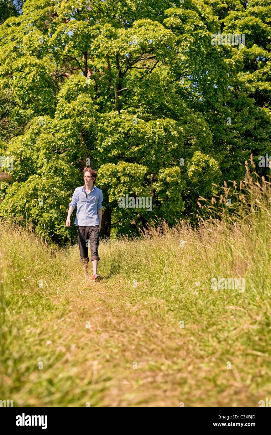 Young man walking in nature Stock Photo - Alamy