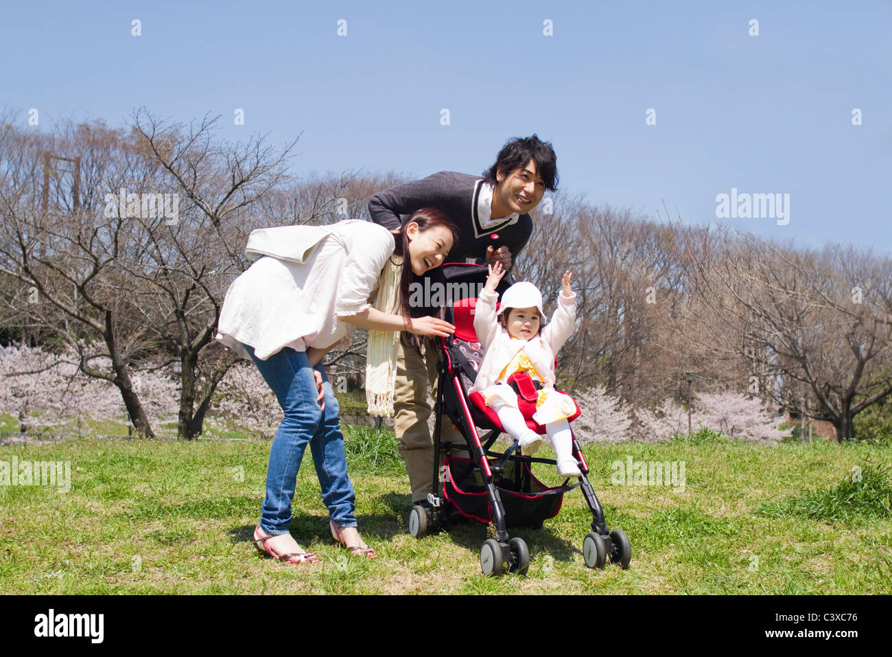 Parents Pushing Daughter in Buggy Stock Photo - Alamy