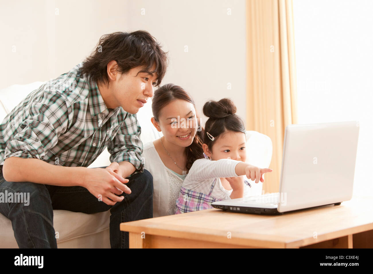 Parents and Daughter Using Laptop Stock Photo - Alamy