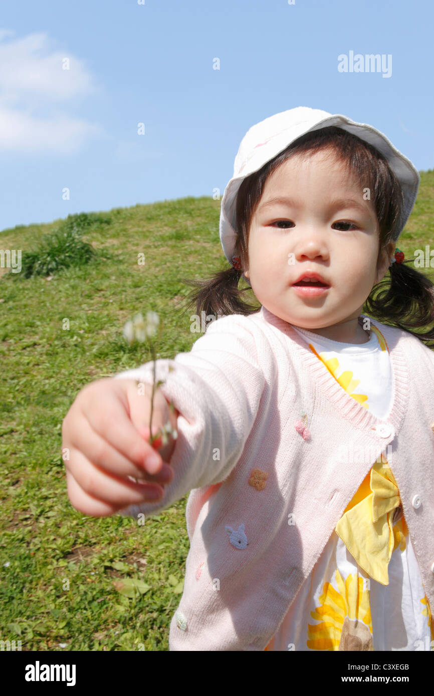 Baby Girl Giving Flower Stock Photo - Alamy
