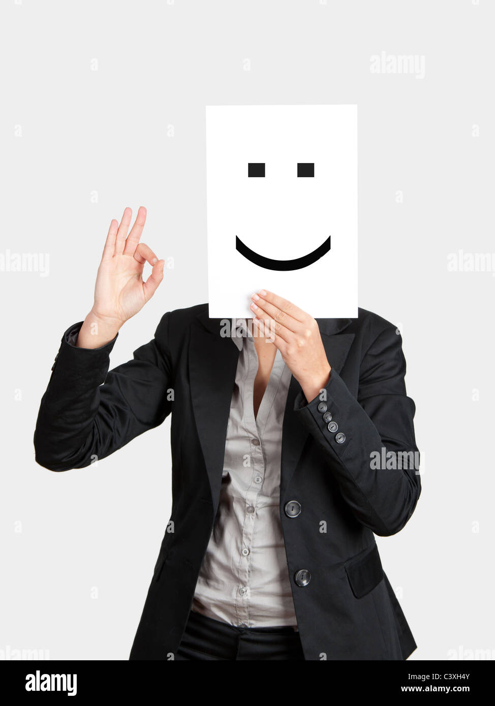 Woman showing a happy emotion in front of face and making okay gesture ...