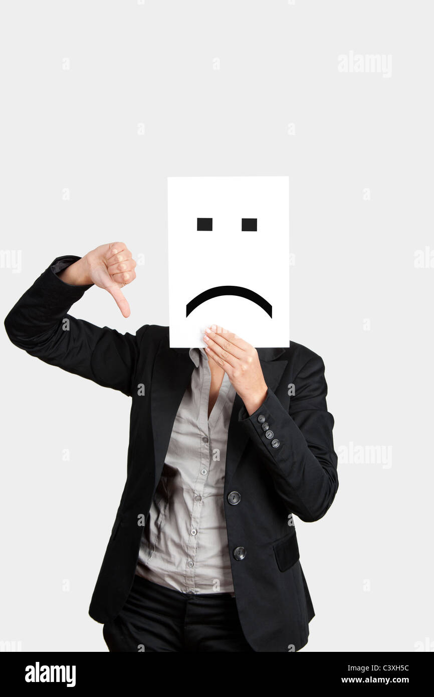 Woman showing a sad emotion in front of face and making a thumbs down ...