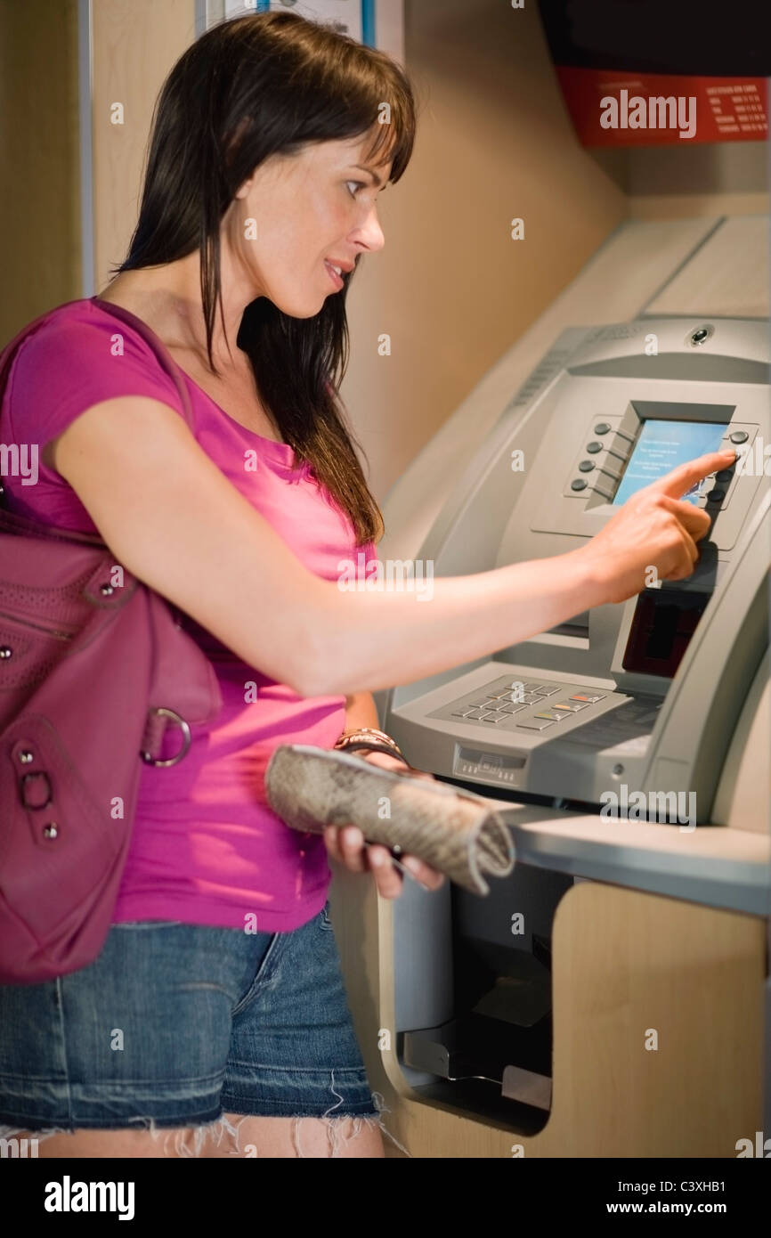 Woman at a cashpoint Stock Photo - Alamy