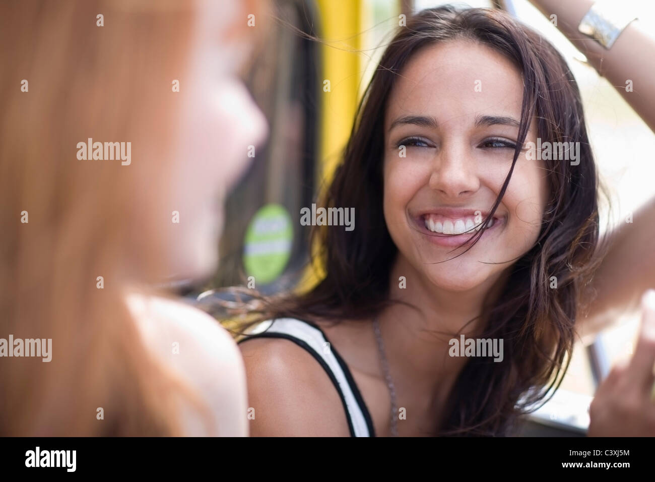 2 Girl friends smiling at each other Stock Photo - Alamy