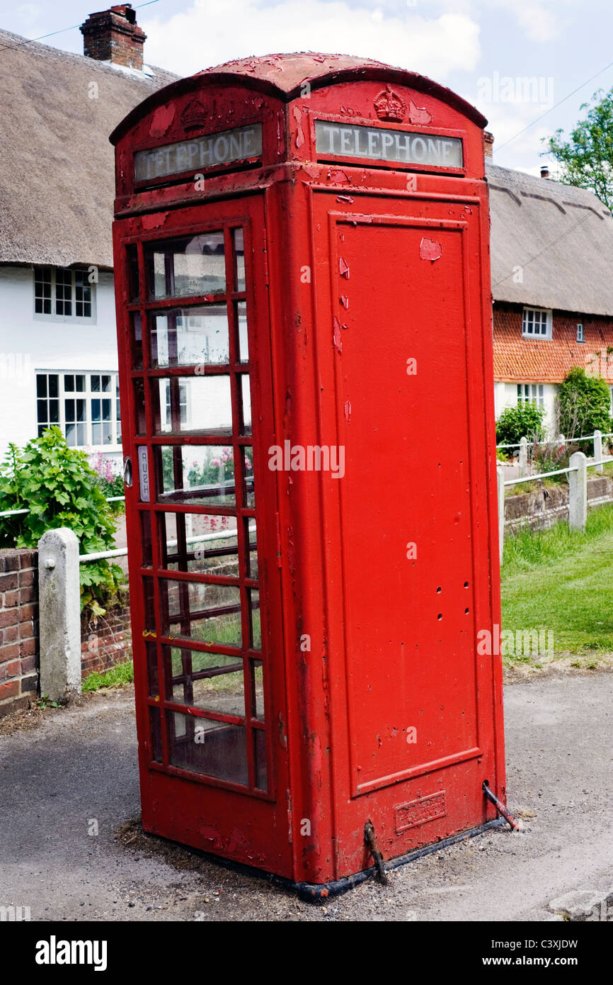 old traditional red telephone box with peeling paint in english village ...