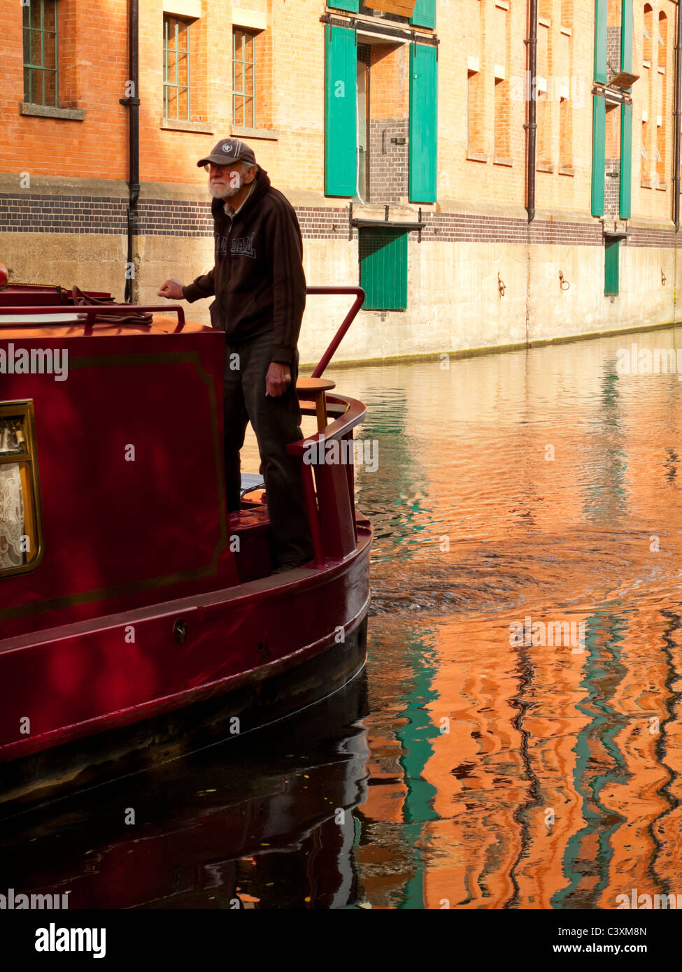 Man sailing red barge near lock in Nottingham city centre canal England ...