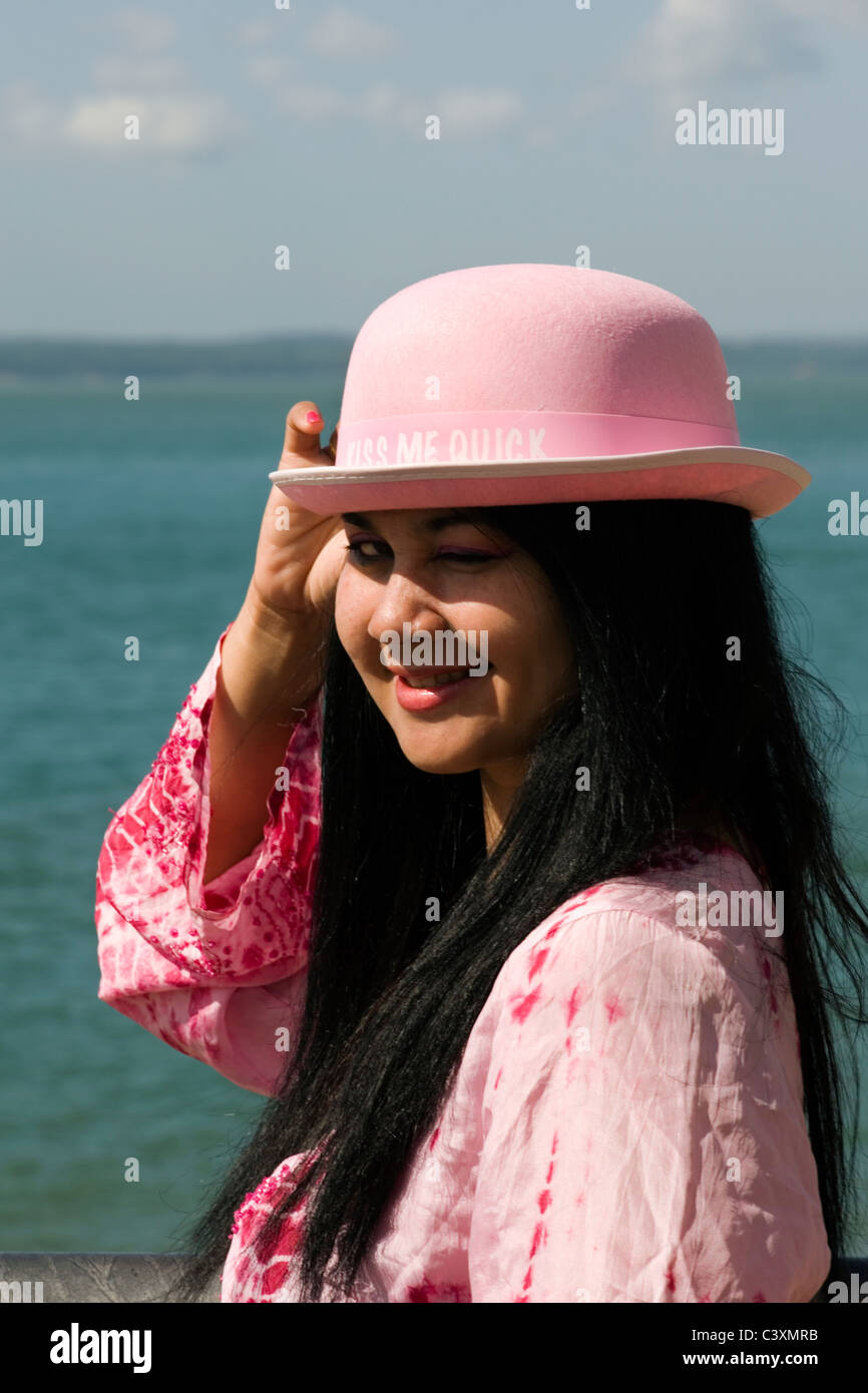 pretty woman at the seaside wearing traditional kiss me quick hat Stock ...