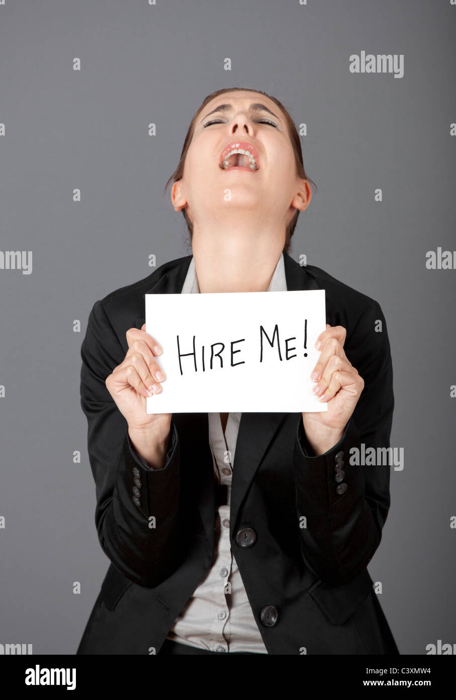 Business woman holding a card board with the text message "Hire me" and ...