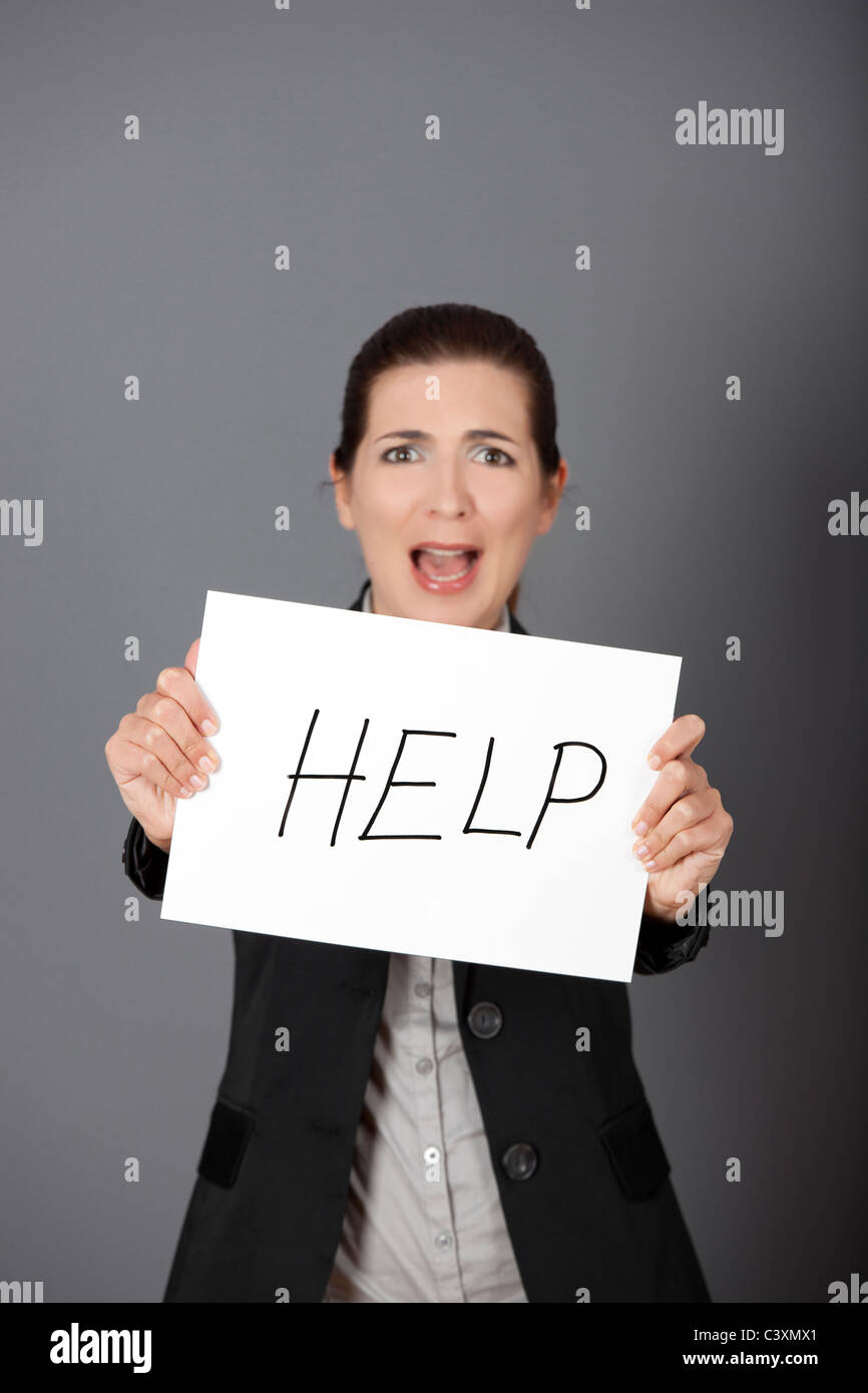 Stressed business woman imploring for help, holding a cardboard with ...