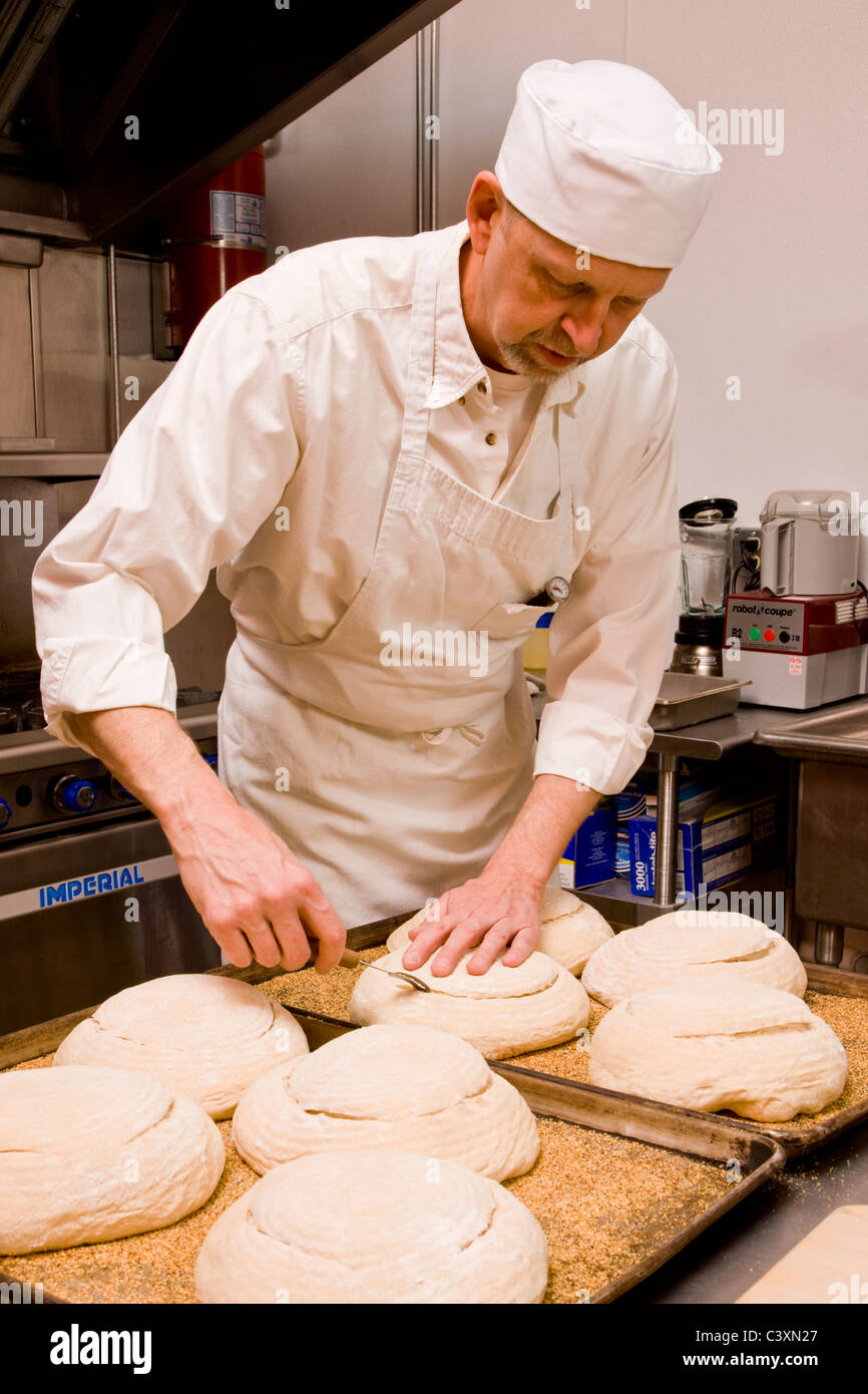 Professional cook preparing fresh bread in a commercial bakery Stock ...